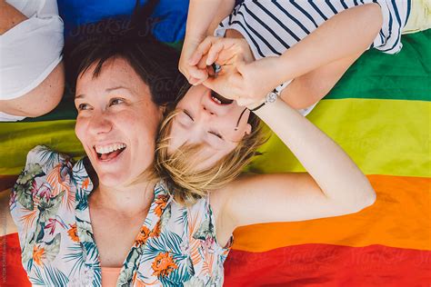Mom And Daughter Having Fun While Lying Over A Lgbt Flag By Stocksy