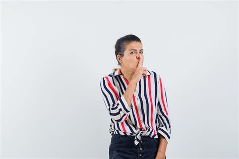 여자 셔츠 치마에 침묵 제스처를 보여주는 조심 찾고 무료 사진