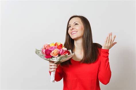 아름 다운 장미 꽃의 꽃다발을 들고 빨간 옷에 젊은 웃는 여자는 흰색 배경에 고립 광고에 대 한 공간을 복사 합니다 성 발렌타인의 날 또는 국제 여성의 날 개념 2월에 대한