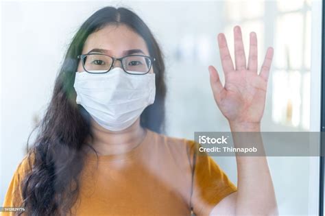 아시아 여성의 초상화는 상담에서 카메라를 보면서 손에 보호 장갑을 끼고 정지 제스처를하고 오렌지 드레스에 위생 보호 마스크를