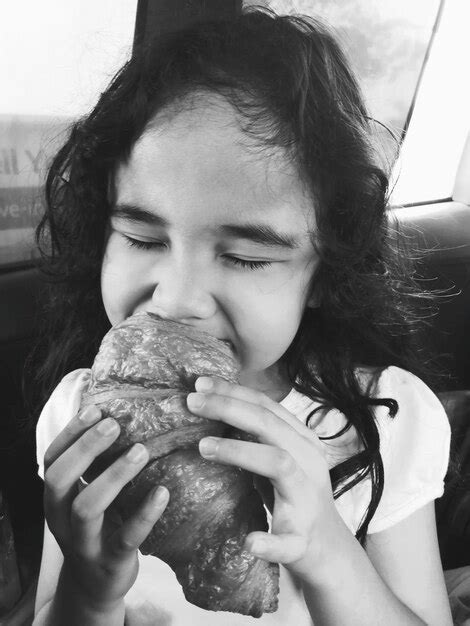 Premium Photo Cute Girl Eating Croissant In Car