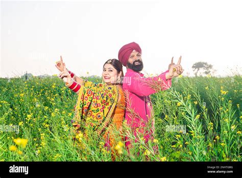 Happy Punjabi Sikh Couple Doing Bhangra Dance In Agriculture Field