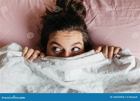 Scared And Surprised Young Woman With Open Eyes Hiding Face Under