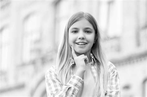 Portrait Of Happy Teen Girl Smiling With Finger On Cheek Blurry