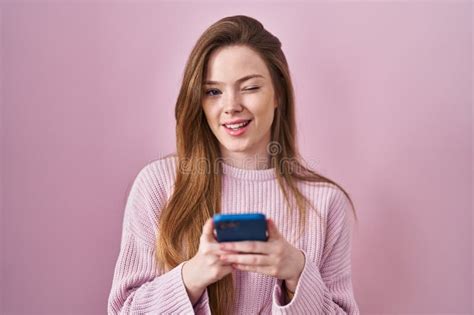 Young Caucasian Woman Using Smartphone Typing Message Winking Looking
