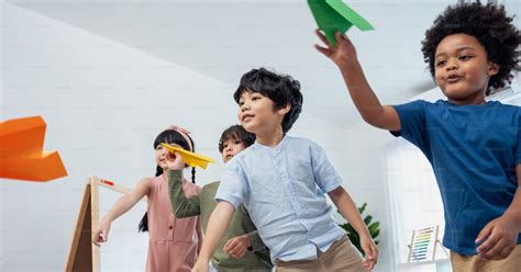 혼혈 어린 아이가 교실에서 비행기를 타고 있다 어린 소녀와 소년 학생은 학교 교실에서 함께 즐거운 시간을 보내면서 휴식 시간에