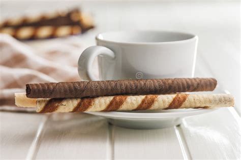 Assorted Chocolate And Vanilla Cream Filled Wafer Rolls And Coffee Cup