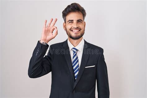 Young Hispanic Man With Tattoos Wearing Business Suit And Tie Smiling