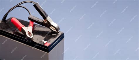 연결된 볼트 충전 배터리 양극 및 음극 파란색 배경 프리미엄 사진