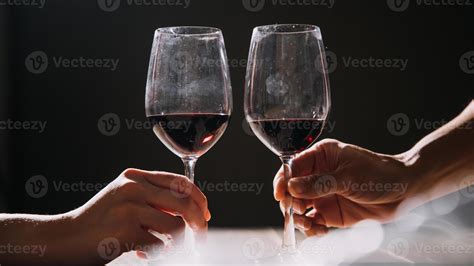 Set Of Hands Holding Red Wine Glass Isolated On Black Background