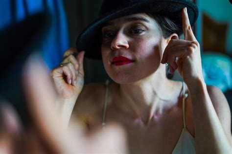 Premium Photo Young Woman Looking At Herself In The Mirror After Put