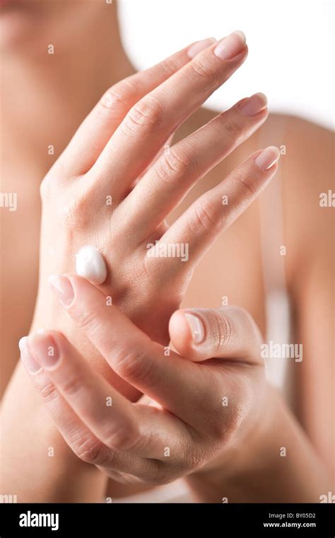 Smiling Young Woman Applies Cream On Her Hands On A White Background