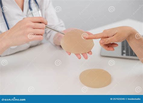 Caucasian Woman And Plastic Surgeon Choosing Breast Implants Stock