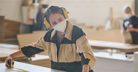 보호 헤드폰과 마스크를 쓴 젊은 여자는 줄자를 사용하여 나무 판을 측정합니다 사진 Unsplash의 줄자 이미지
