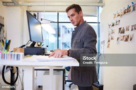 스탠딩 데스크에서 매력적인 중년 사업가가 데스크톱 컴퓨터에 정보를 기록하는 유연한 워크스테이션 아르헨티나 민족에 대한 스톡 사진 및 기타 이미지 Istock