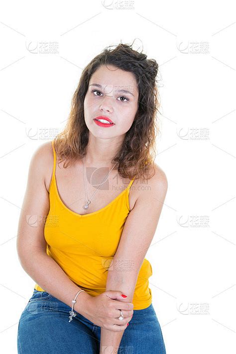 美丽的年轻的黑发女孩站在白色的墙
