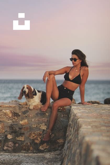 Foto Mujer En Bikini Negro Sentada En Una Roca Cerca Del Mar Durante El