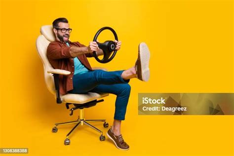 자동차 드라이버 고립 선명한 노란색 색상 배경을 척 스티어링 휠을 유지 의자에 행복 바보 남자의 전체 길이 바디 사진 스티어링