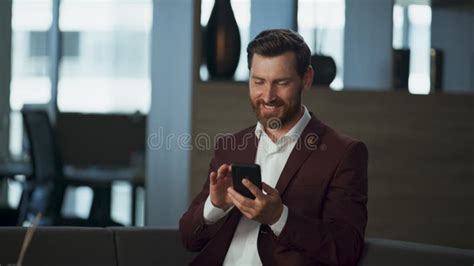 Happy Businessman Typing Smartphone In Corporate Modern Office Smiling