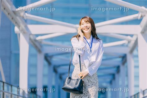 スマホで通話しながら歩く日本人女性ビジネスマンの写真素材 214593509 イメージマート