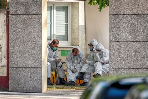 Medics In White Protective Suits Checking And Scanning Passengers In A