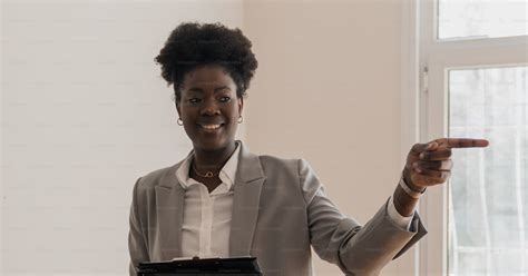 비즈니스 정장을 입은 여자가 무언가를 가리키고 있다 사진 Unsplash의 부동산 이미지