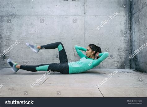 Young Woman Performing Core Crunch Exercise Stockfoto 402876202