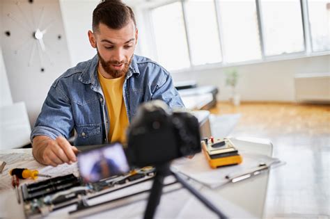 작업장에서 남성 영향력자는 자신의 하루 일을하고 튜토리얼을 촬영 전기 회로 수리에 필요한 다양한 도구와 품목으로 가득찬 작업 테이블 Stem 주제에 대한 스톡 사진 및 기타
