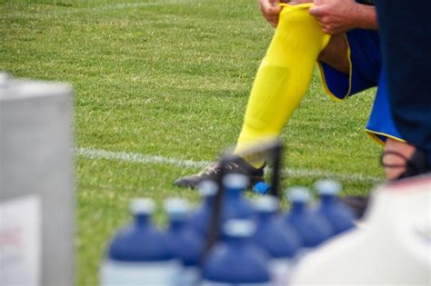 Premium Photo Low Section Of Soccer Player Wearing Sock On Field