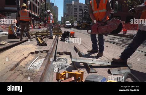 A Construction Worker Gets Ready To Cut A Steel Beam While Other