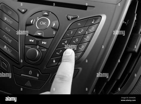 closeup black and white image of woman pressing button on car dashboard