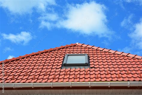 Roofing Construction A Red Metal Roof With A Attic Skylight Window
