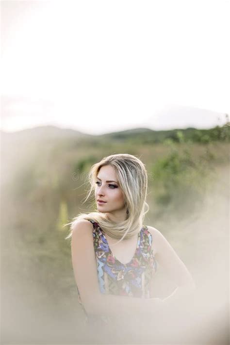 Beautiful Dreamy Blonde Girl With Blue Eyes In A Light Turquoise Dress Lying On The Stones Stock
