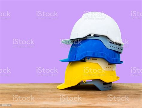 흰색 파란색 및 노란색 헬멧 테이블에 배치 됩니다 기술자의 안전 프로젝트에 대 한 안전 헬멧은 엔지니어 또는 건설 노동자입니다 건설업자에 대한 스톡 사진 및 기타 이미지