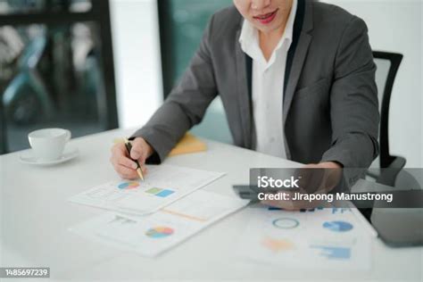 젊은 아시아 남성은 집에서 재정 서류를 가지고 일하며 온라인으로 세금 영수증을 지불하기 전에 계산기를 계산하고 예산을 계획하고 경제가 돈을 절약할 수 있는 기회를 찾고