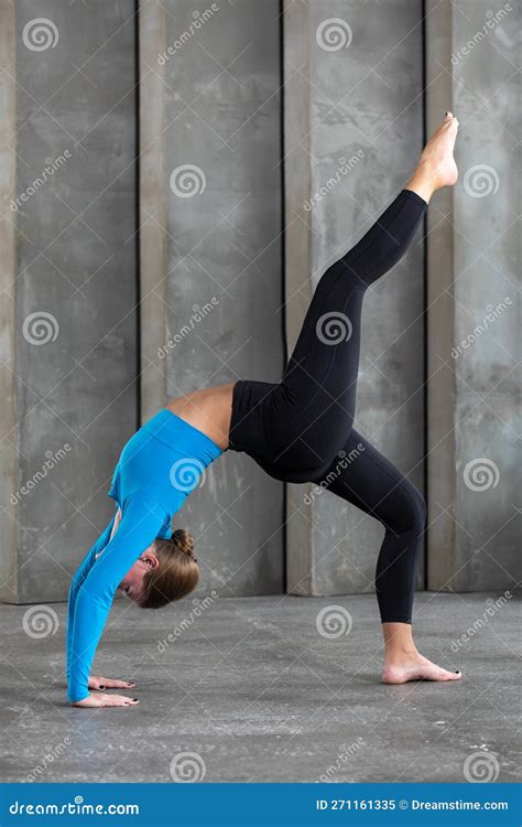 A Young Woman In Sportswear Makes A Gymnastic Bridge The Concept Of
