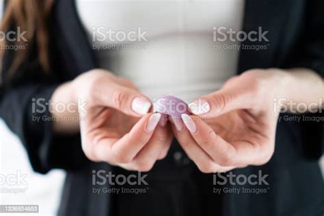 검은 색 클래식 정장과 흰색 상의에 긴 어두운 머리를 가진 소녀는 흰색 배경에 꽃잎과 함께 근무하고 있습니다 건강한 생활방식에