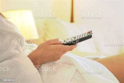 침대에 누워 리모컨을 들고 있는 여성의 전경을 가까이서 볼 수 있는 여유로운 시간 Tv 보기에 대한 스톡 사진 및 기타 이미지