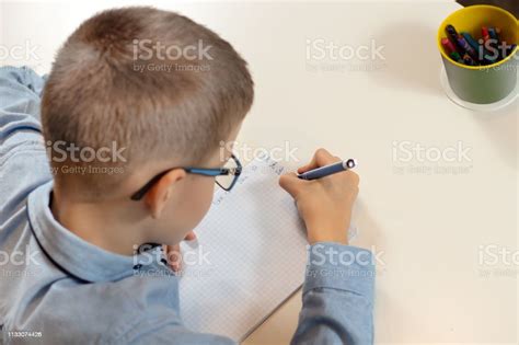 서 면으로 훈련 하는 소년의 손 체크 무늬 노트북에 펜으로 편지를 씁니다 공부에 대한 스톡 사진 및 기타 이미지 공부 교육