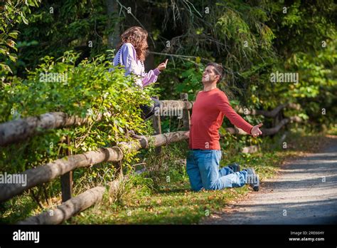 Guy On His Knees Asking A Girl To Marry Him On A Country Road In