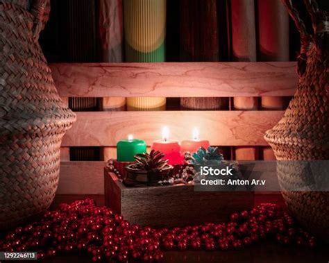 불타는 양초와 소나무 콘은 나무 쟁반에 있습니다 근처에는 빨간 구슬 고리버들 바구니 종이 롤이 있는 나무 상자가 있습니다 크리스마스 구성 0명에 대한 스톡 사진 및 기타