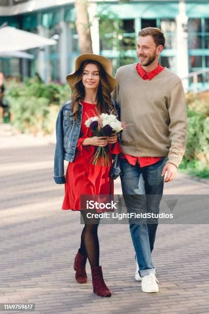 쾌활 한 남자가 꽃을 들고 모자에 매력적인 여자 친구와 함께 산책 2명에 대한 스톡 사진 및 기타 이미지 2명 걷기 꽃 식물 Istock