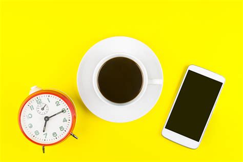 에스프레소 블랙 빈 스크린 모바일 스마트폰 복사 공간와 노란색 배경에 클록의 커피 컵 화이트 아침 식사는 아침 러시아워 미니