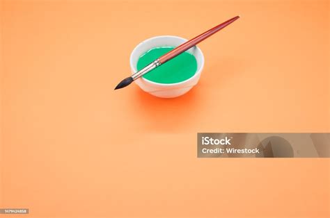 그릇에 담긴 녹색 수채화와 주황색 배경에 격리된 붓의 근접 촬영 0명에 대한 스톡 사진 및 기타 이미지 0명 그림 그리기 녹색 Istock