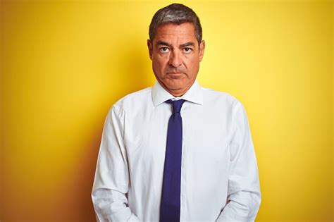 고립 된 노란색 배경 회의론자와 긴장 때문에 문제의 눈살을 찌푸리게 화가 위에 서 잘 생긴 중년 사업가 부정적인 사람 감정에 대한 스톡 사진 및 기타 이미지 Istock