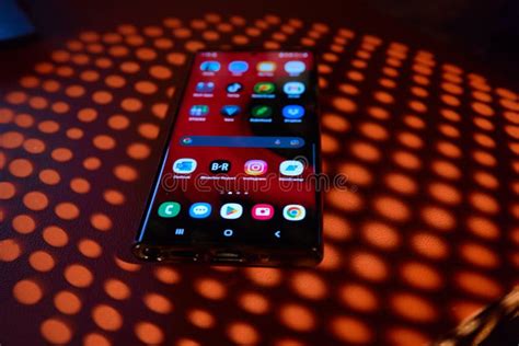 cell phone with bright apps showing on table editorial photography