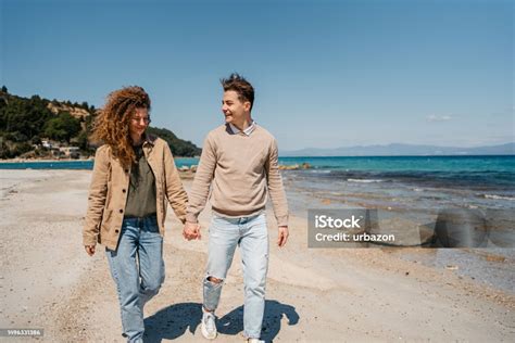 Photo Libre De Droit De Un Jeune Couple Se Promène Sur La Plage En