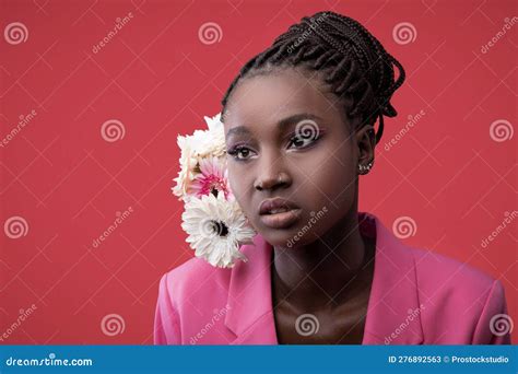 Stylish African American Woman With Flowers In Hair Posing On Red