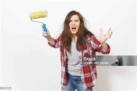 벽 그림을 흰색 배경에 고립 비명 페인트 롤러 들고 캐주얼 옷에 젊은 미친 정신 여자 악기 재건축 아파트 룸에 대 한 도구입니다