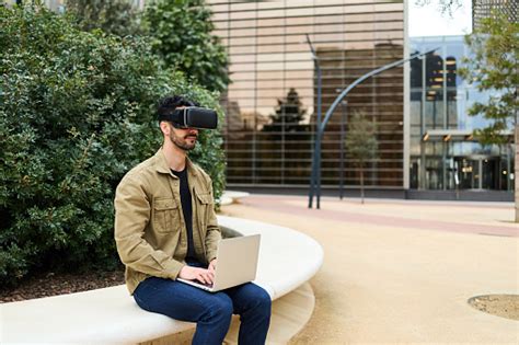 한 사업가가 야외에 앉아 노트북으로 작업하면서 자연 환경과 디지털 환경이 혼합된 가상 현실 경험에 몰두하고 있습니다 3차원 형태에 대한 스톡 사진 및 기타 이미지 Istock